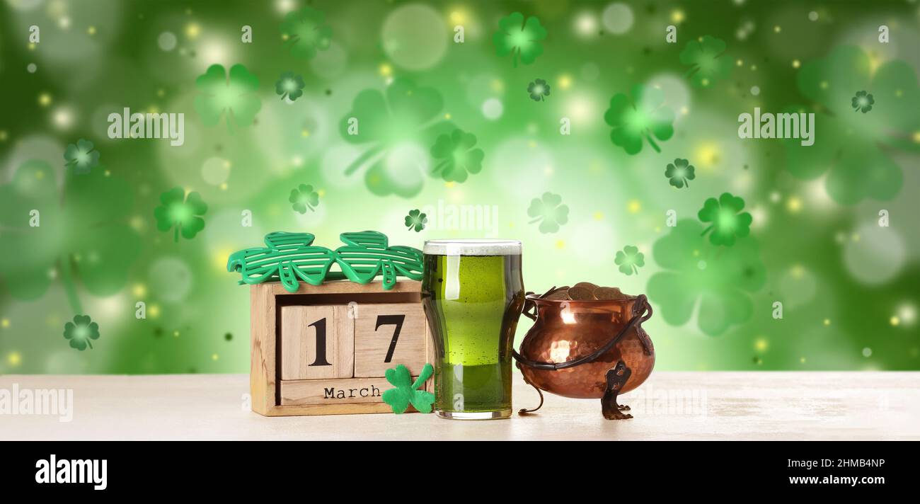 Calendar, pot with coins and glass of beer on table against green ...