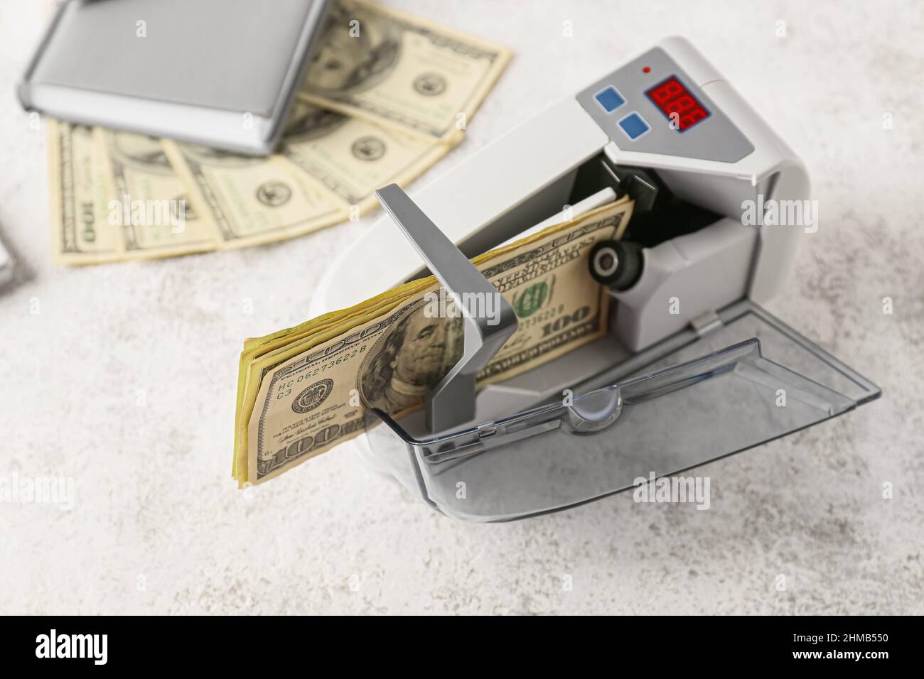 Money in currency counting machine on light table Stock Photo - Alamy