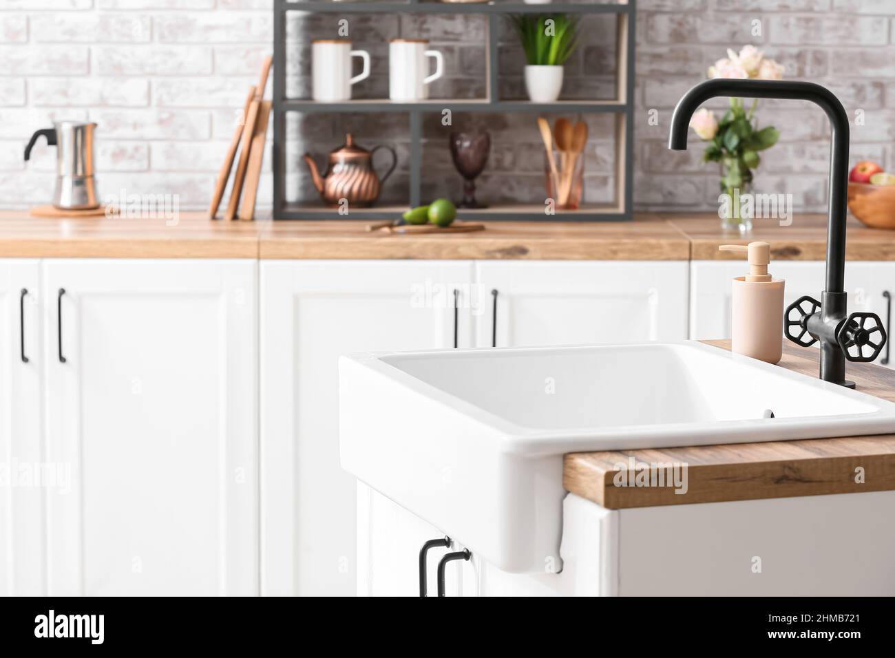 Wooden counter with ceramic sink and dish wash detergent in kitchen ...