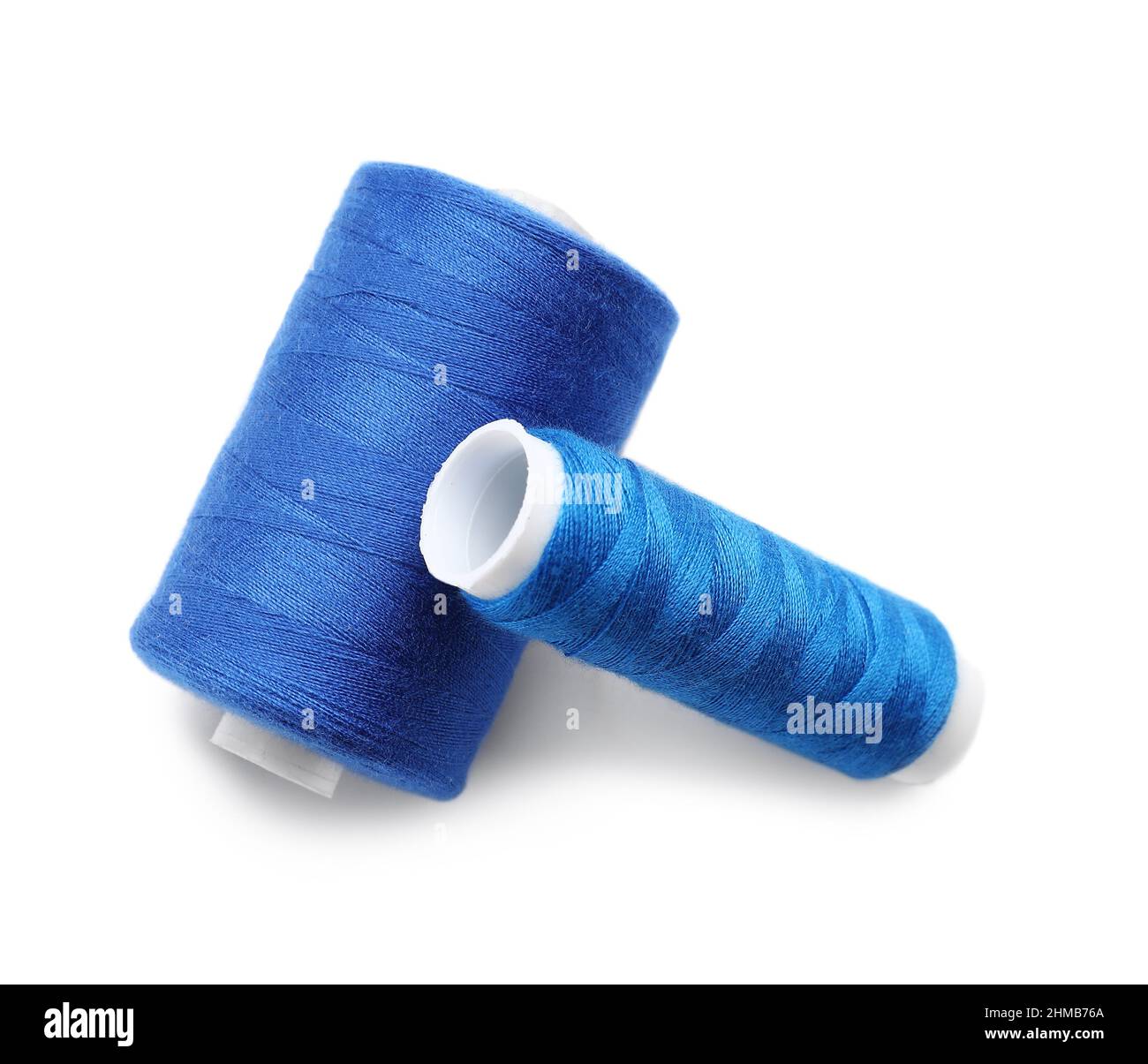 Blue sewing thread spools on white background Stock Photo - Alamy