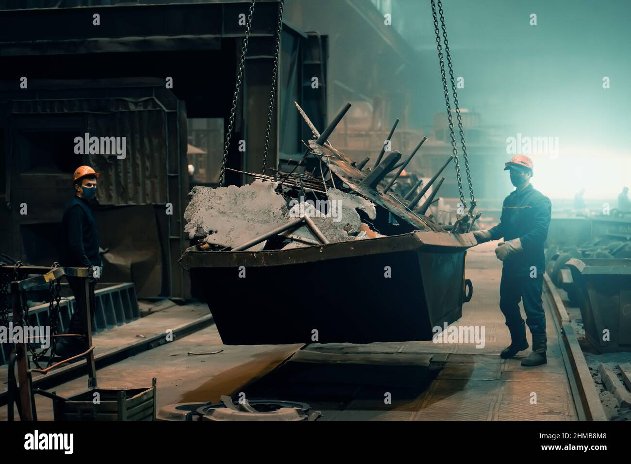 Workers at metallurgical plant. Working with scrap metal. Metal ...