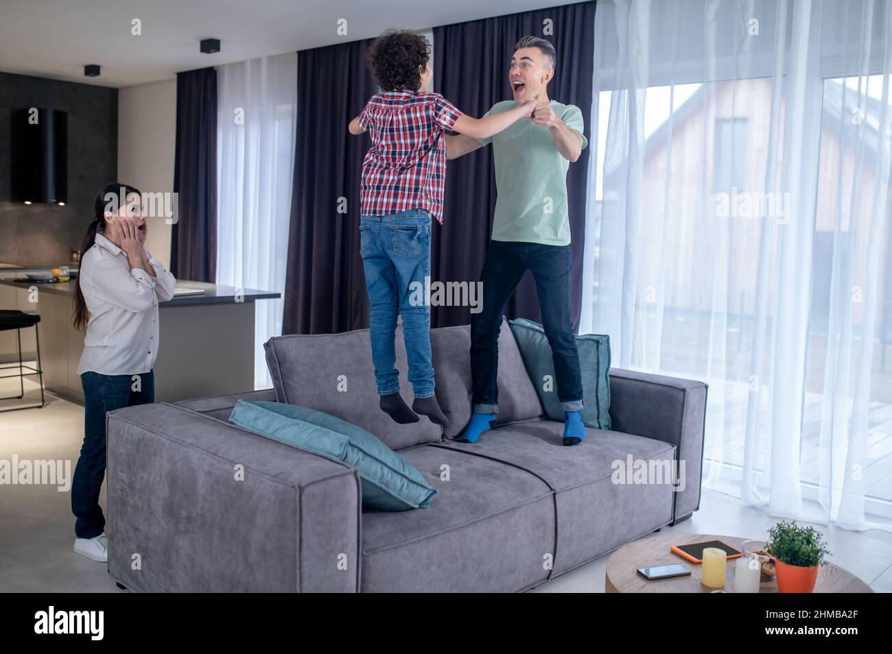 Boy jumping on sofa hi-res stock photography and images - Alamy
