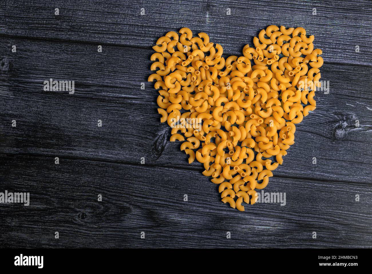 a heart of pasta and pasta on a wooden background.the symbol of all ...