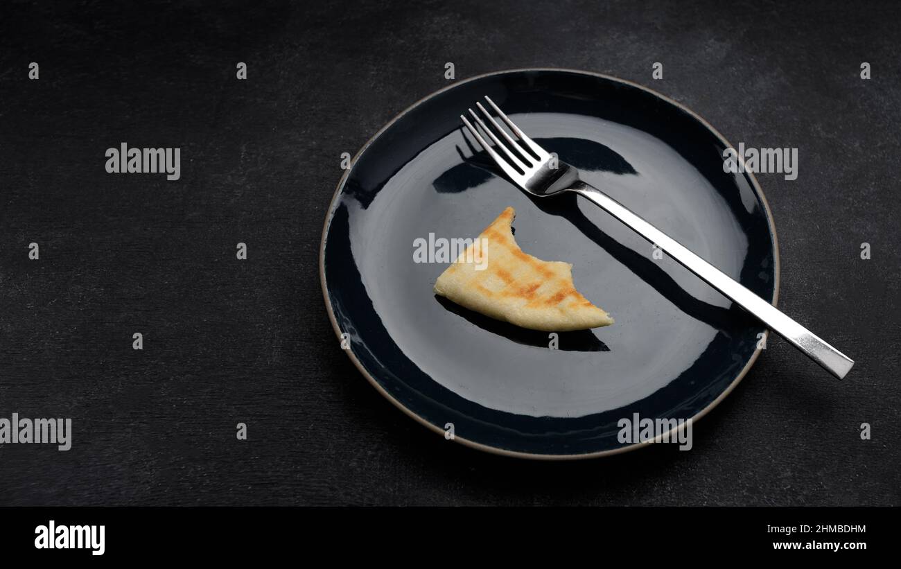 Empty plate with bitten off piece of bread and fork Stock Photo - Alamy