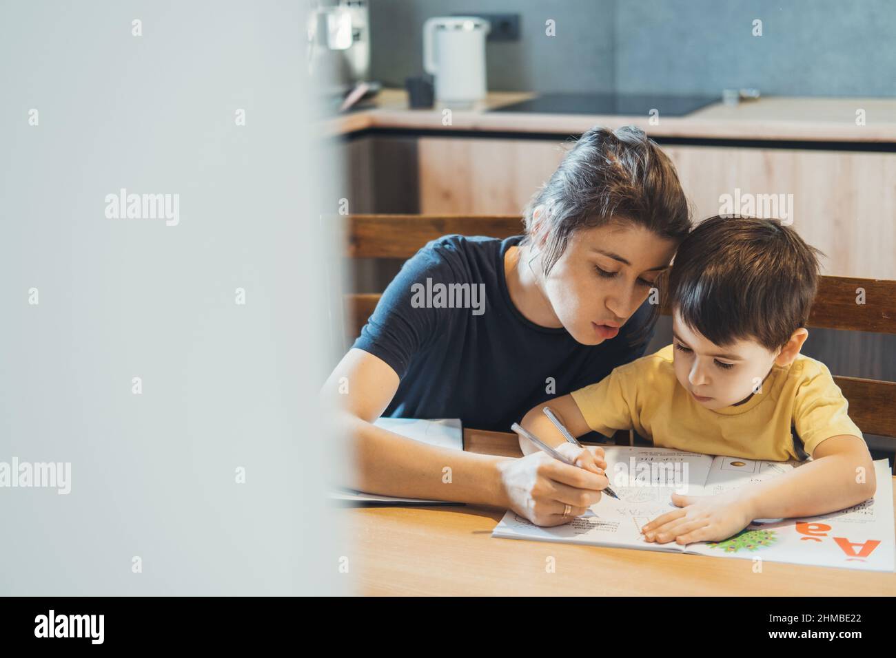 Mother helping son doing homework at home. Parent helping child. Schoolboy Stock Photo - Alamy