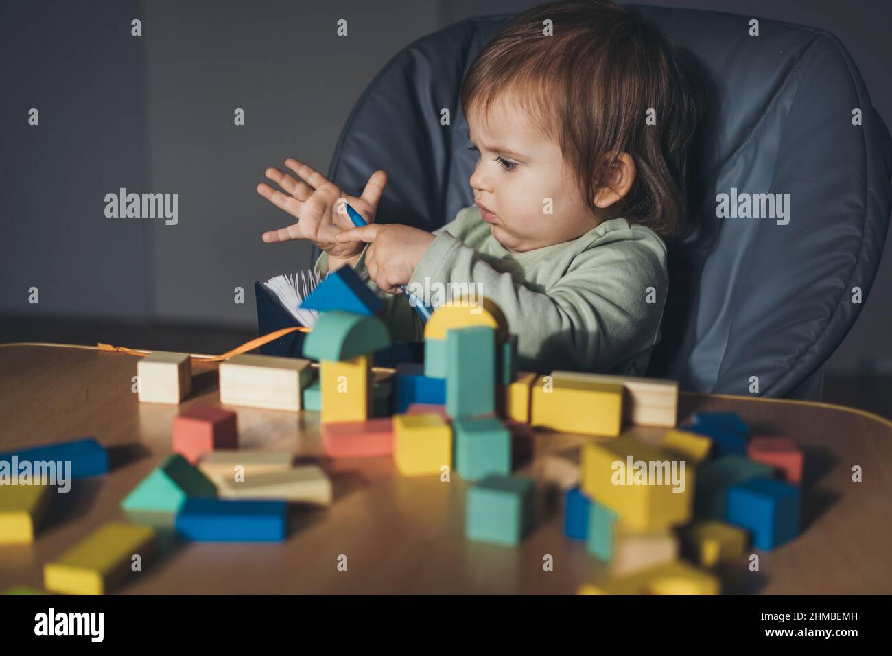 Baby girl playing with connecting toy cubes at home. Children education ...