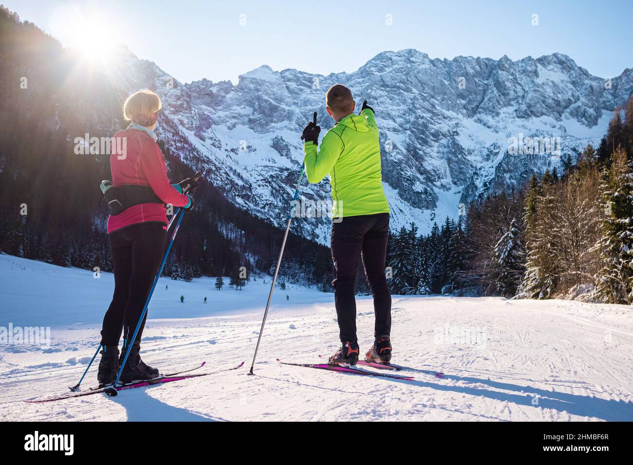 Caucasian couple cross country skiing one behind the other, making ...