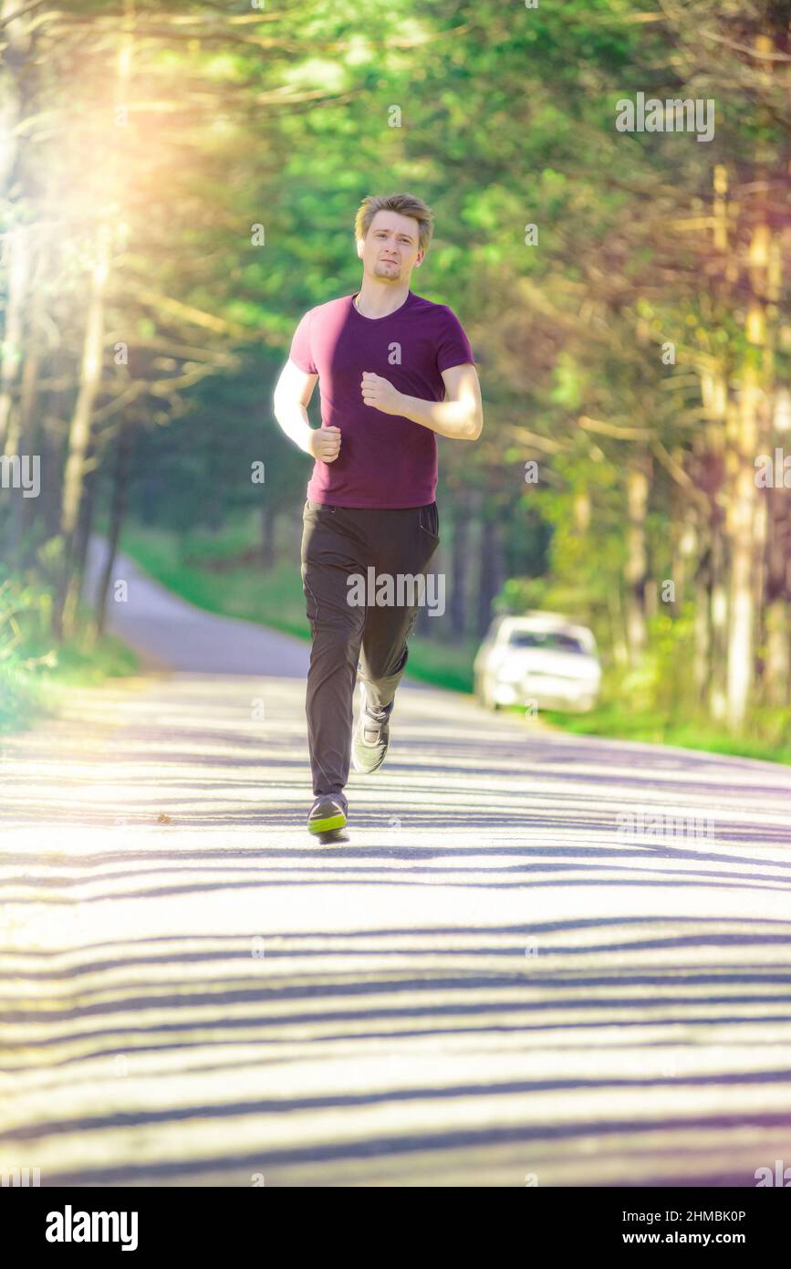 Running man jogging in city park at beautiful summer day. Sport fitness ...