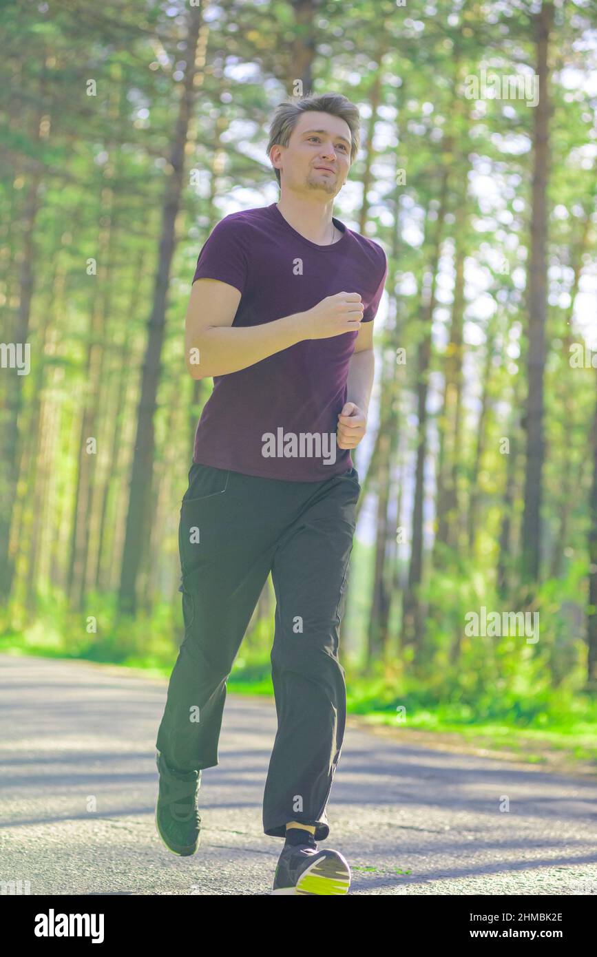 Running man jogging in city park at beautiful summer day. Sport fitness ...