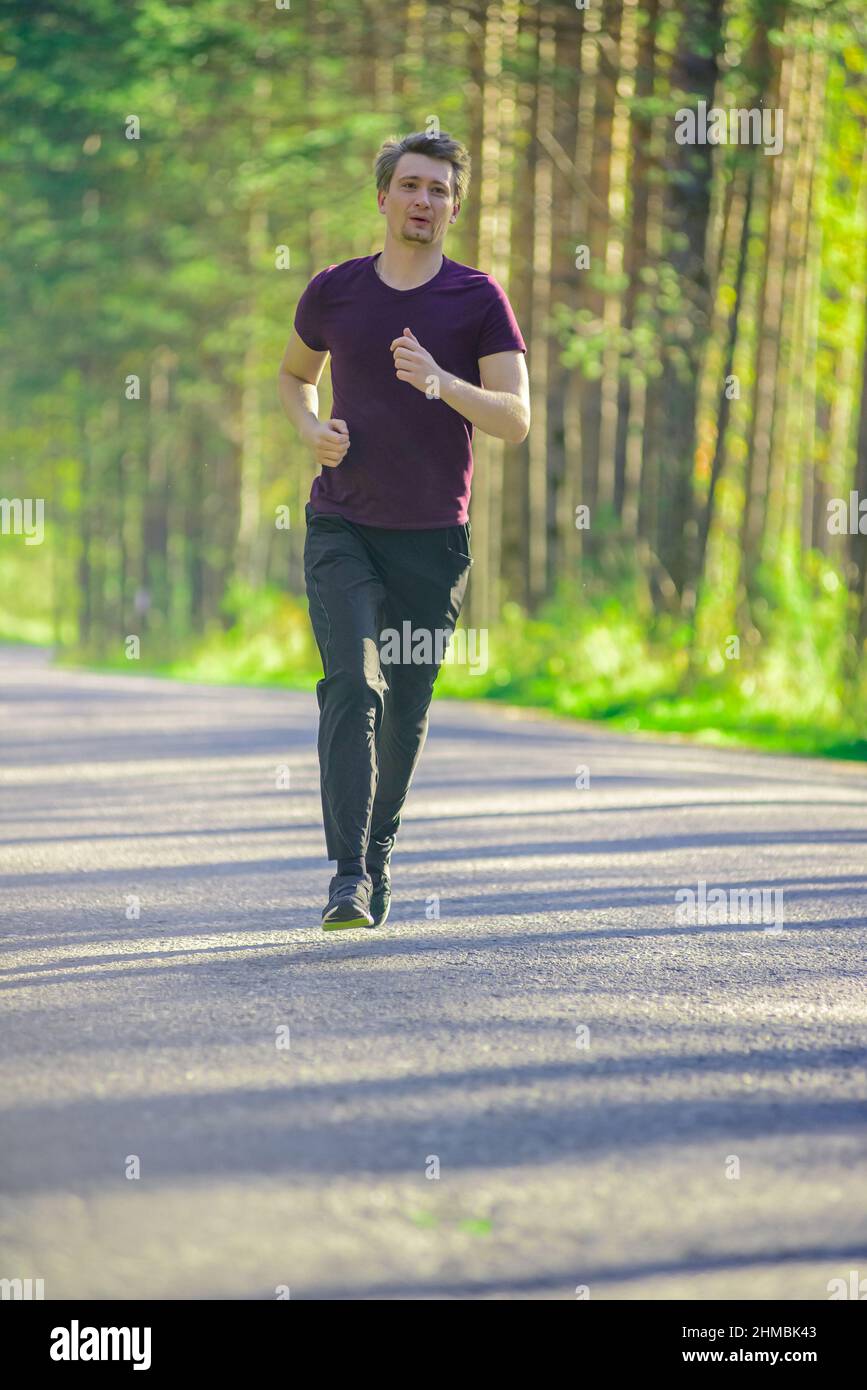 Running man jogging in city park at beautiful summer day. Sport fitness ...
