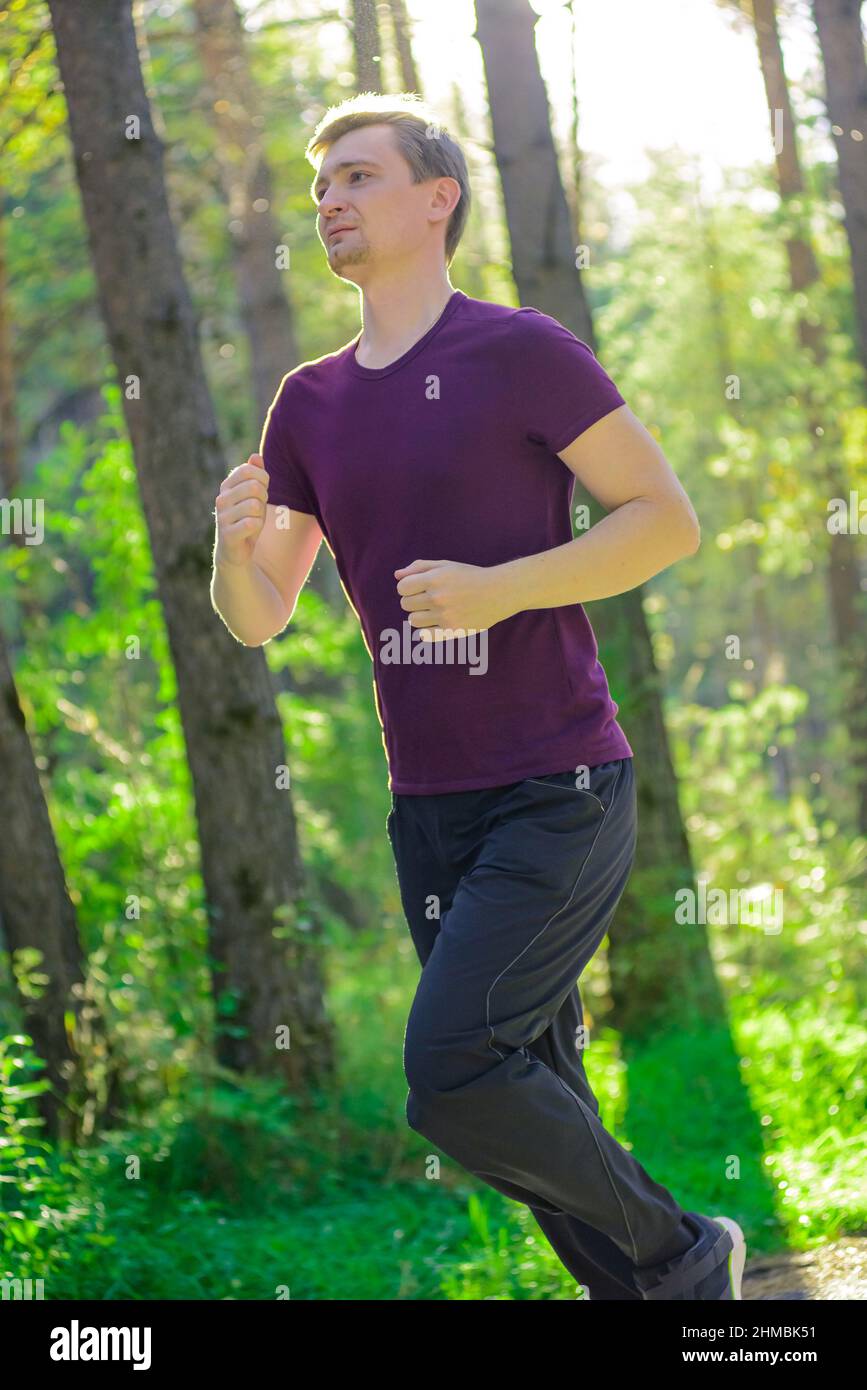 Running man jogging in city park at beautiful summer day. Sport fitness ...