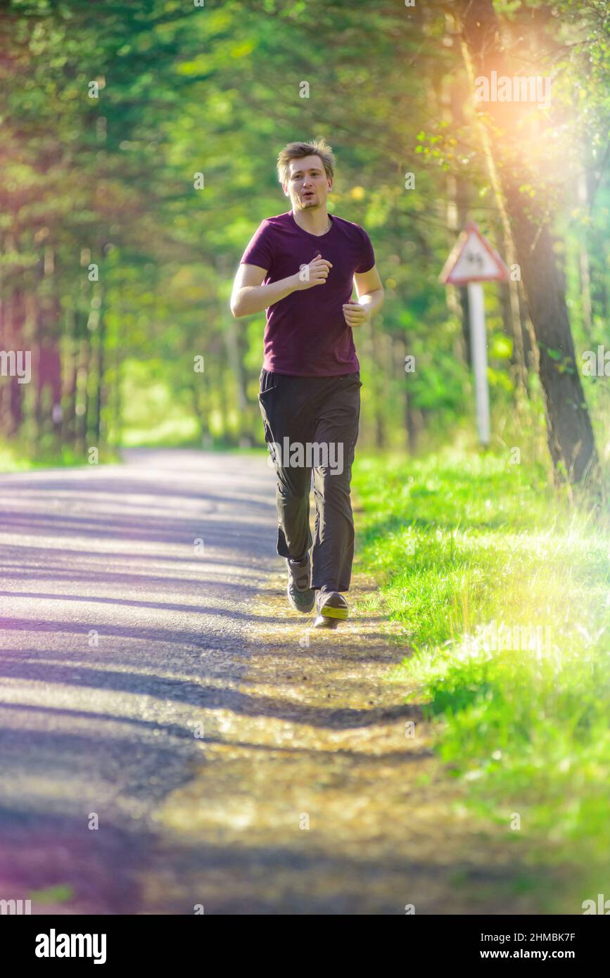 Running man jogging in city park at beautiful summer day. Sport fitness ...
