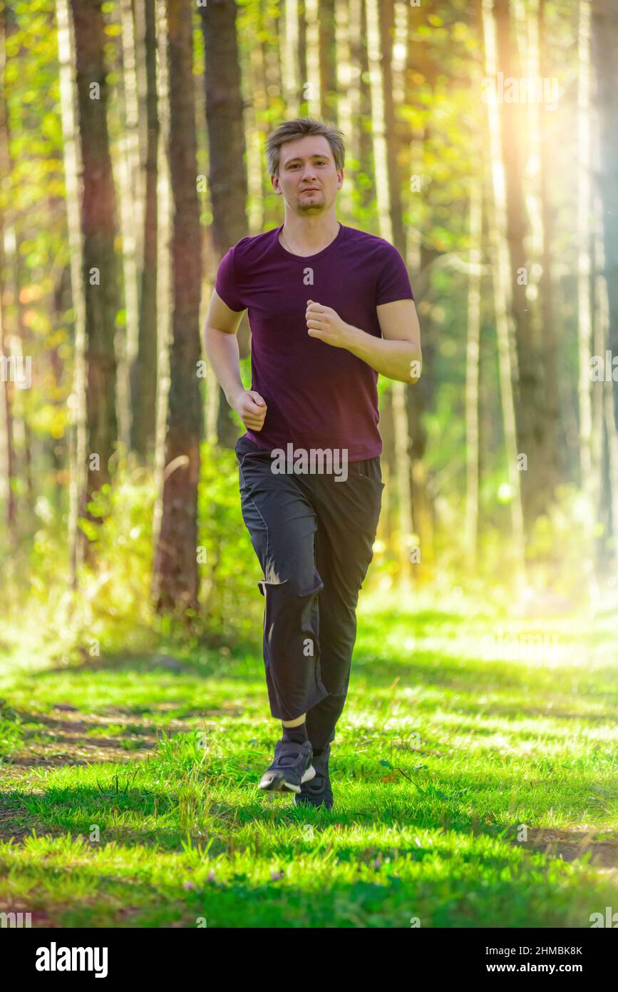 Running man jogging in city park at beautiful summer day. Sport fitness ...