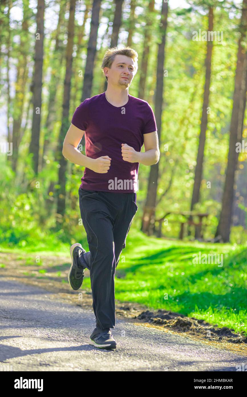 Running man jogging in city park at beautiful summer day. Sport fitness ...