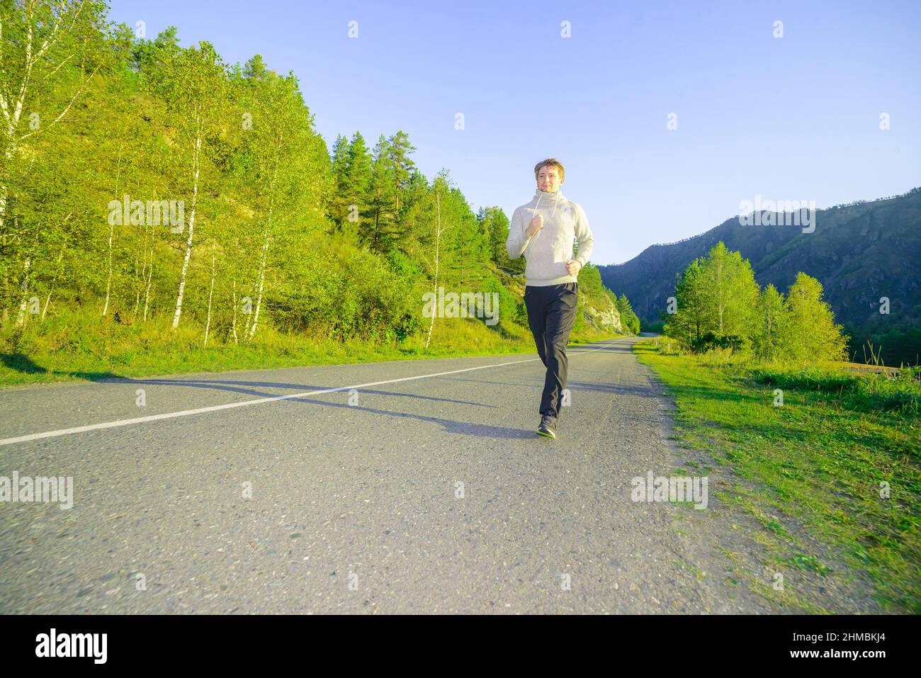 Running man jogging in city park at beautiful summer day. Sport fitness ...