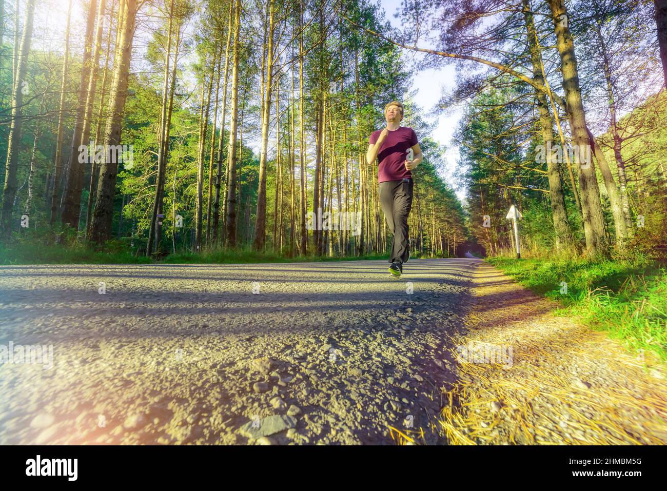 Running man jogging in city park at beautiful summer day. Sport fitness ...