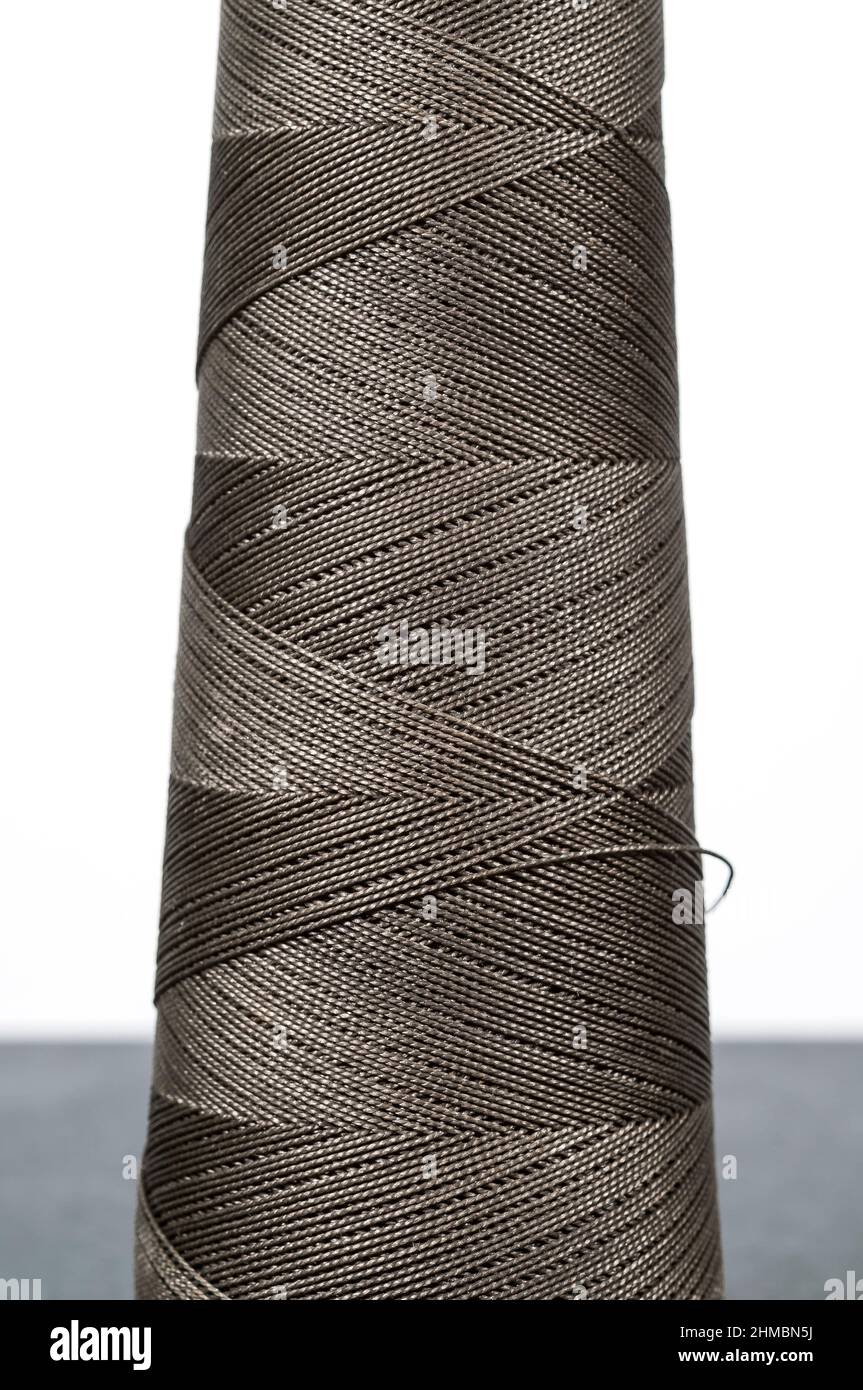 A conical shaped tube of dark string or twine with patterns in the wrap ...