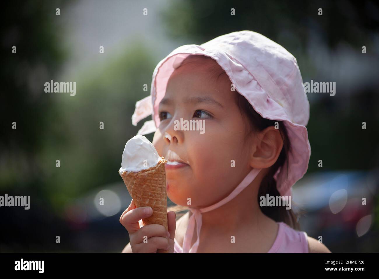 A child eats ice cream. The girl bites the sweetness. Summer ice cream ...