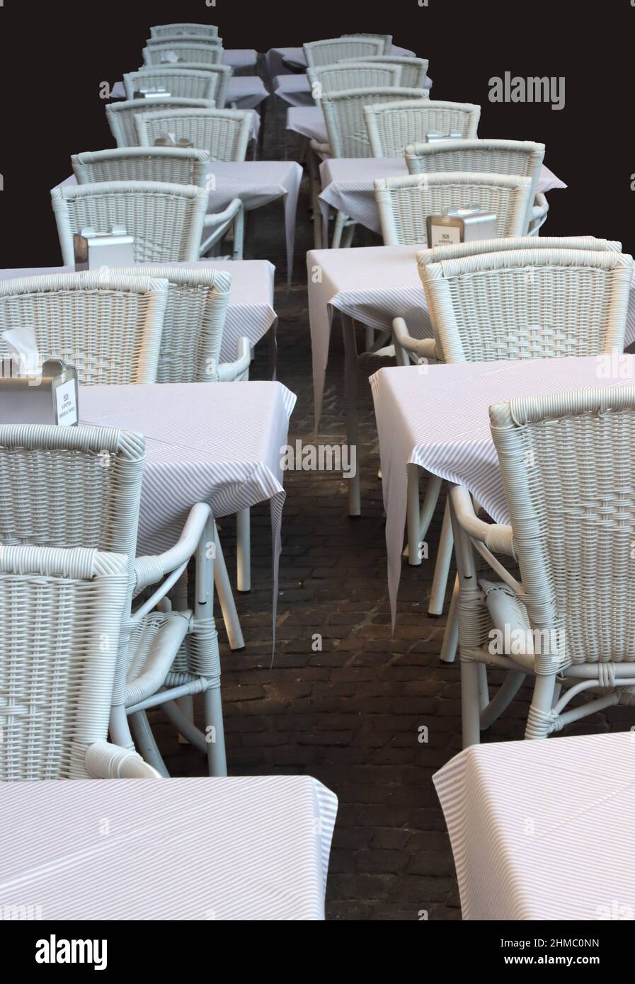 Vertical shot of a row of white tables and chairs in a restaurant Stock ...
