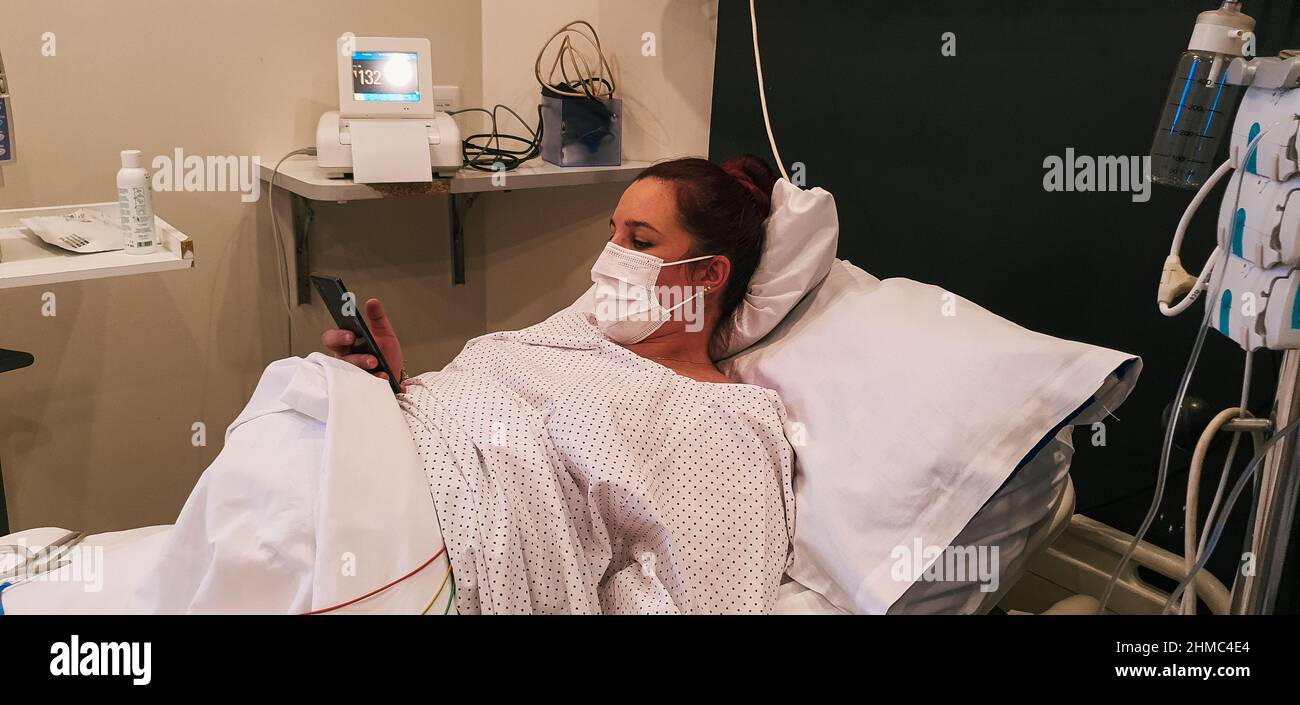pregnant young woman dilating in delivery room, using smartphone Stock ...
