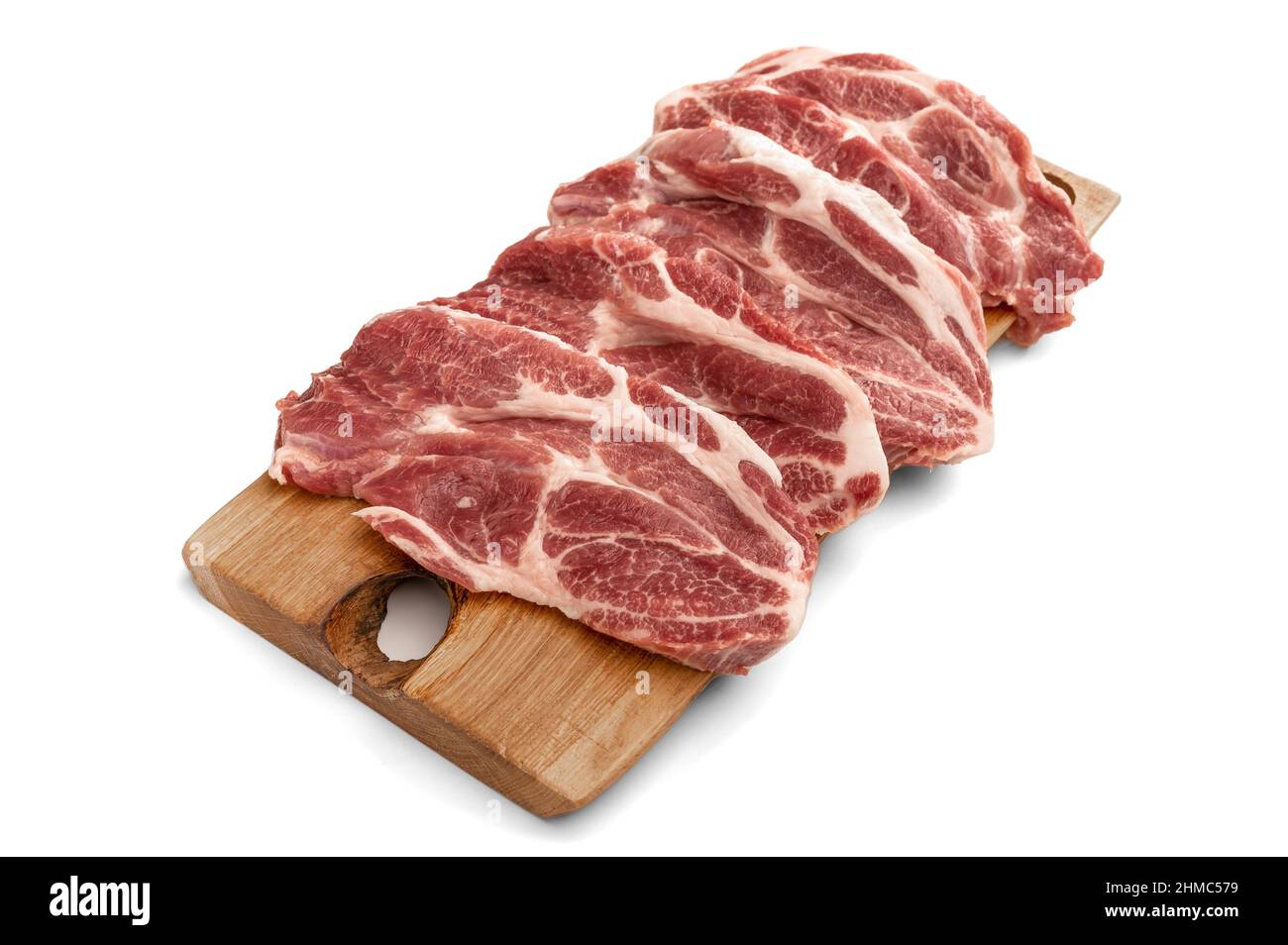 Raw pork sliced meat on wooden board on white background. Heap of ...