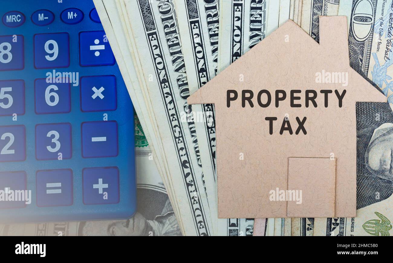 Property tax text on brown paper house model with dollar banknotes and ...