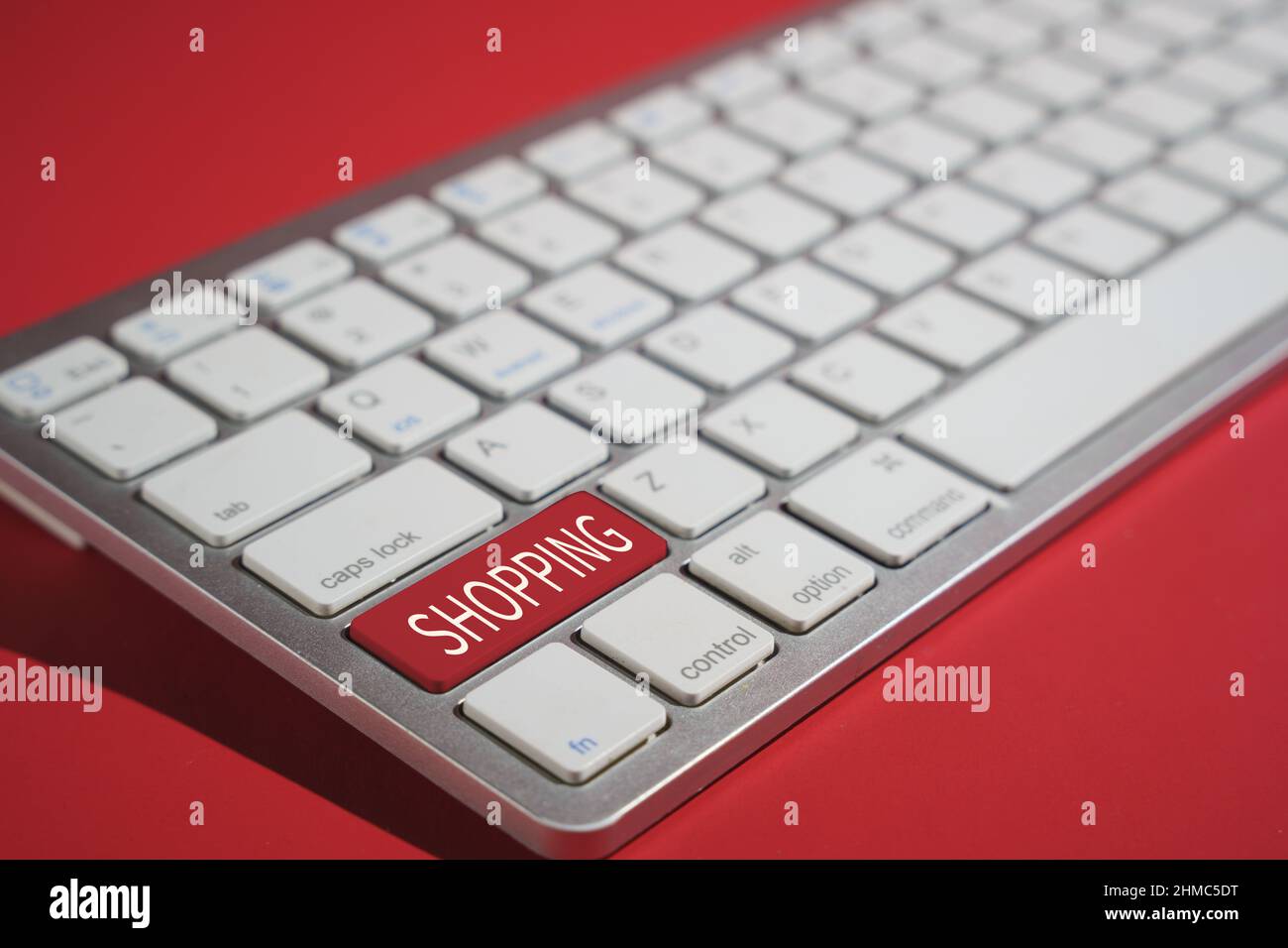 Closeup shot of shopping text on a computer keyboard isolated on red ...
