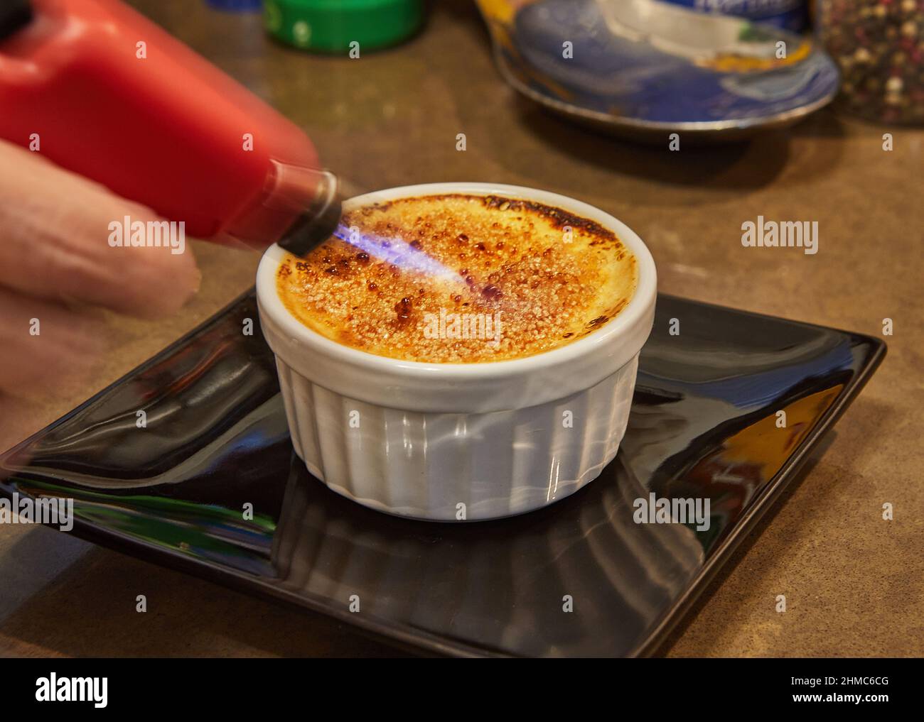 Creme brulee with mushrooms in special form, the chef burns sugar with ...
