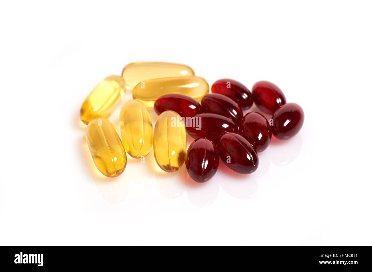 Yellow omega-3 fish oil capsules and red black cumin oil capsules Stock ...