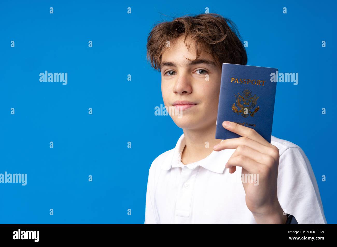 Portrait of glad handsome boy showing his passport going on vacation ...