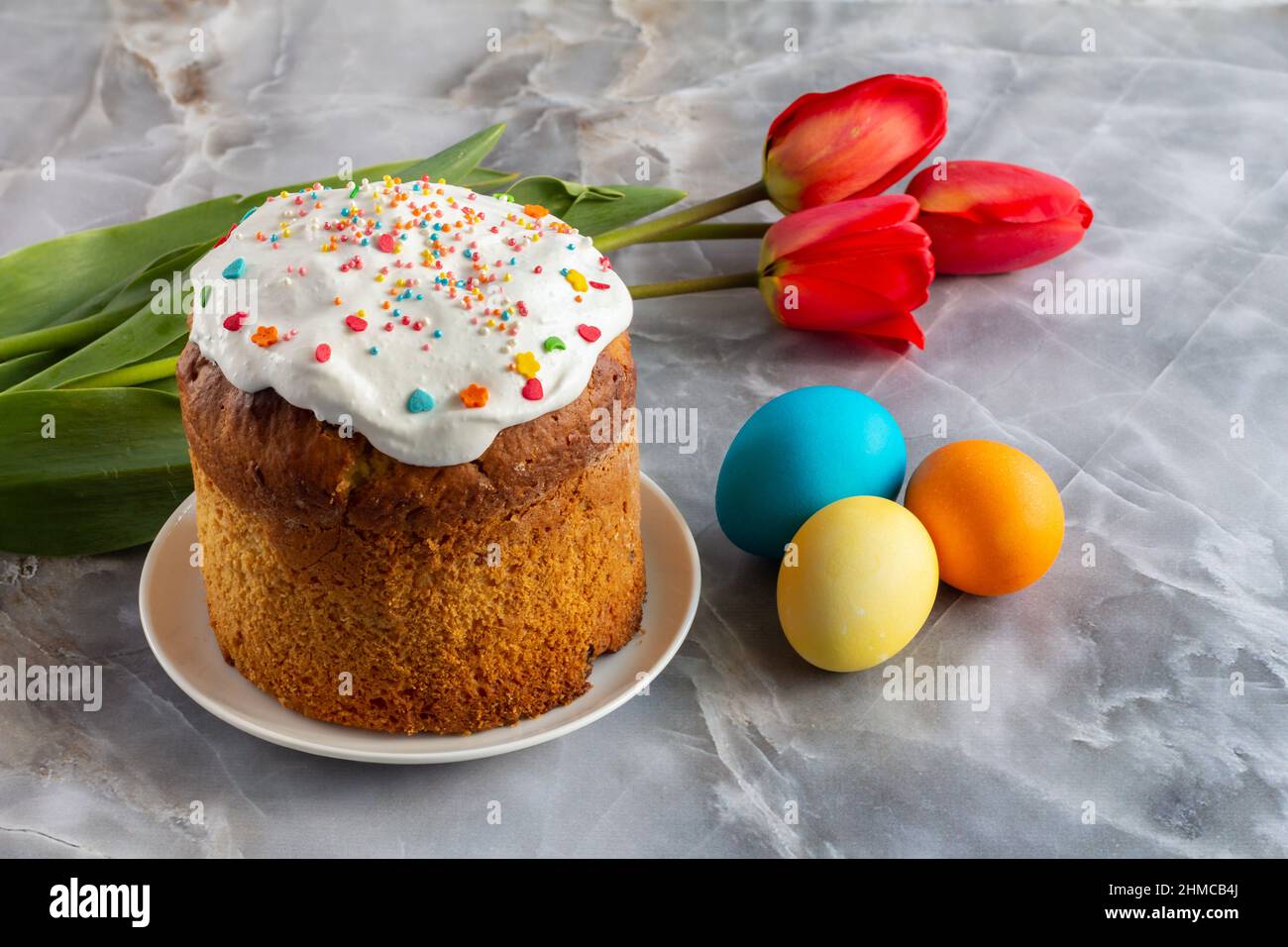 Easter cake and colorful Easter eggs with tulip flowers. Traditional ...