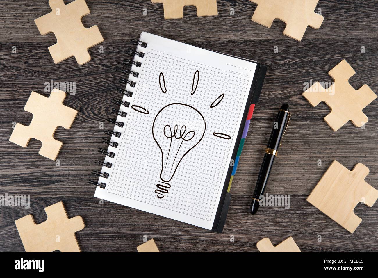 notepad with a pen and puzzle pieces closeup Stock Photo - Alamy