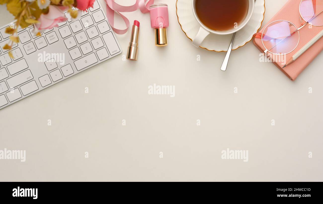 Top view of a beautiful feminine workspace with keyboard, cosmetics ...