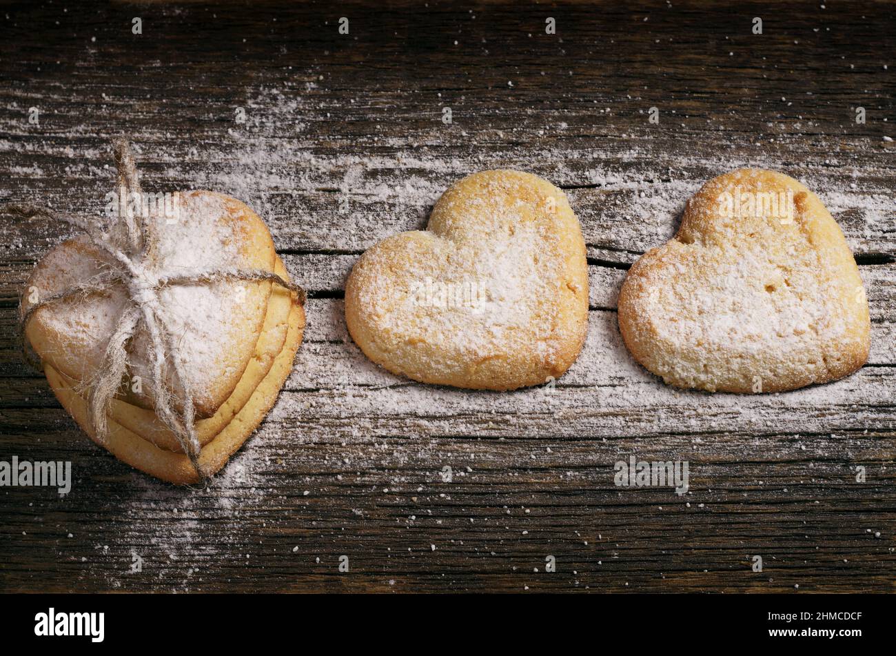 Heart-shaped shortbread cookies tied with a rope and two separate ones ...