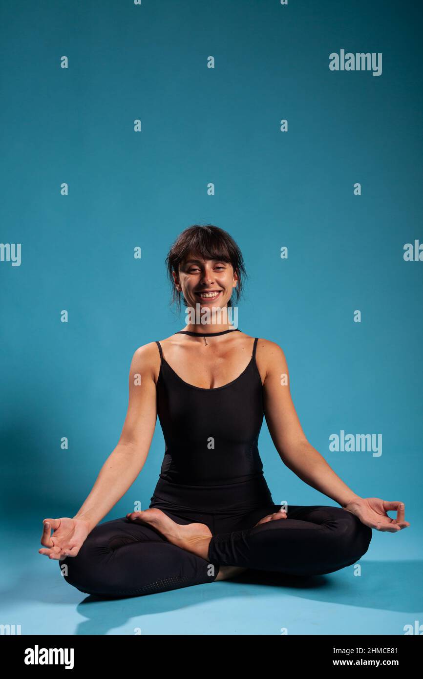 Athletic woman meditating during gymnastics workout sitting in ...