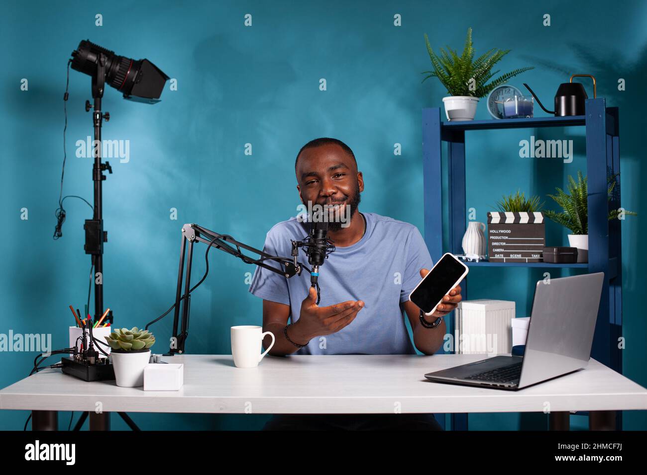 Vlogger announcing new giveaway on social media presenting smartphone ...