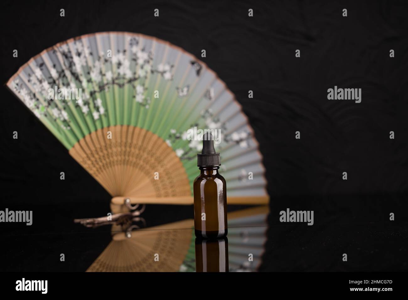 Beautiful shot of a bottle of essential oil with a hand fan on a ...