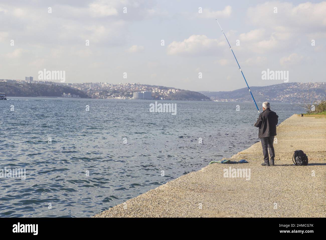 Back view of an old man fishing in a lake Stock Photo - Alamy