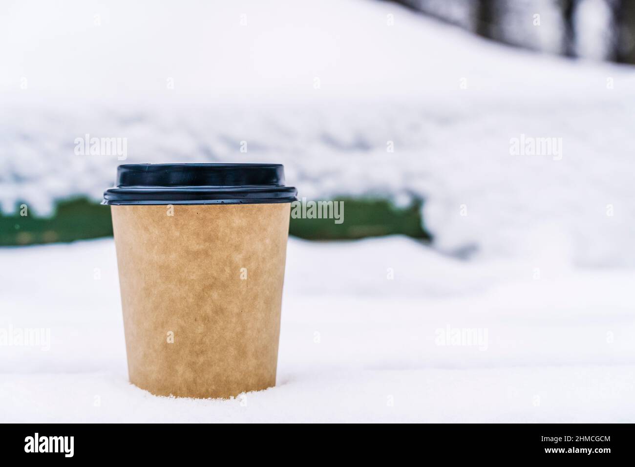 Coffee in a paper cup on a snowy winter background. Hot drink in cold ...