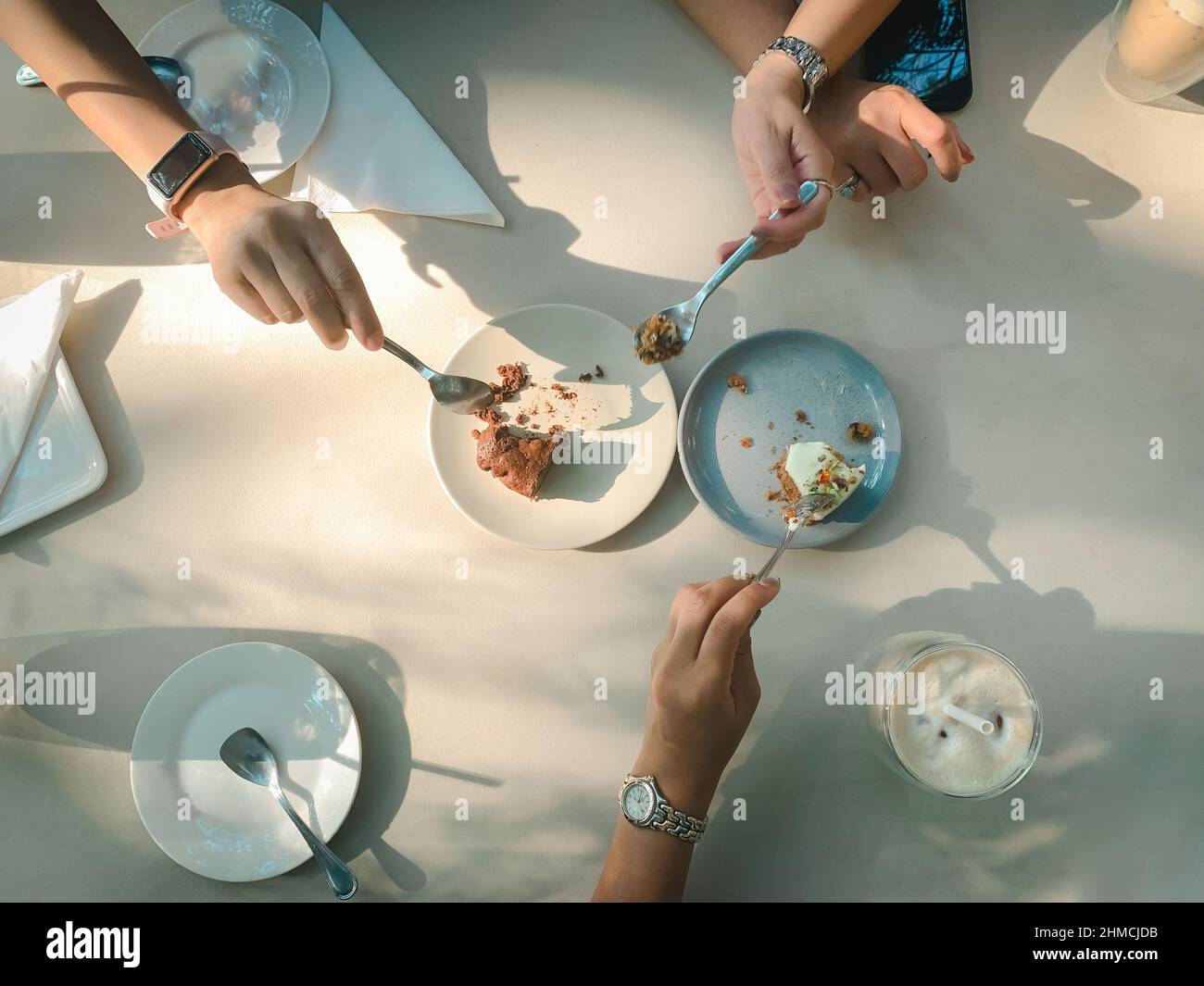 Hand with spoon enjoy eating cake in cafe. Top view Stock Photo - Alamy