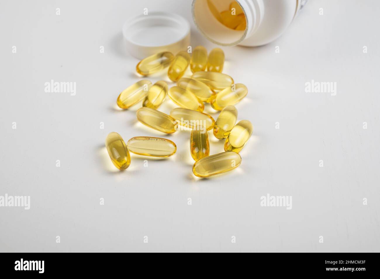 Gold fish oil isolated on white background. Pile of fish oil with Omega ...