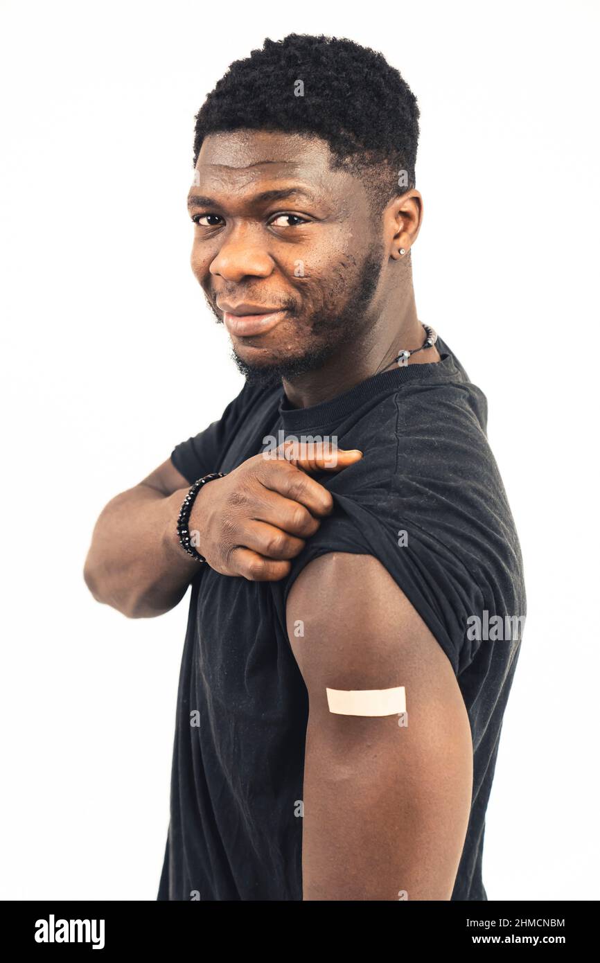 black man vaccinated showing arm looking to the camera and smiling ...