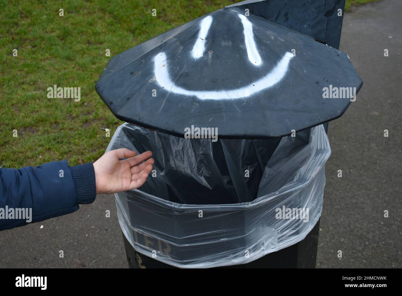 close up of child's hand putting her trash in a litter bin with a ...