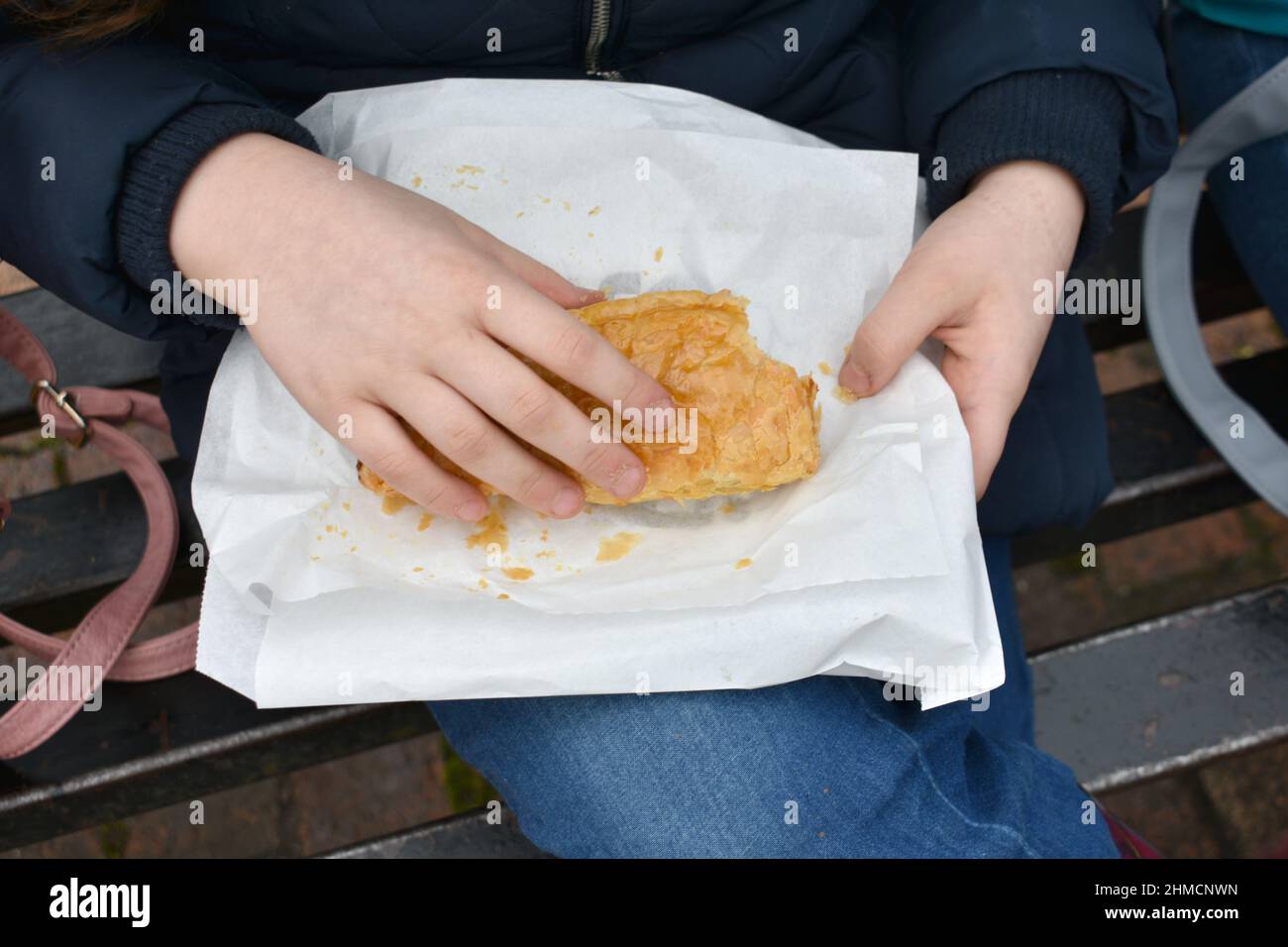 close up of young girl's hands holding a pastry snack. The child's hand ...