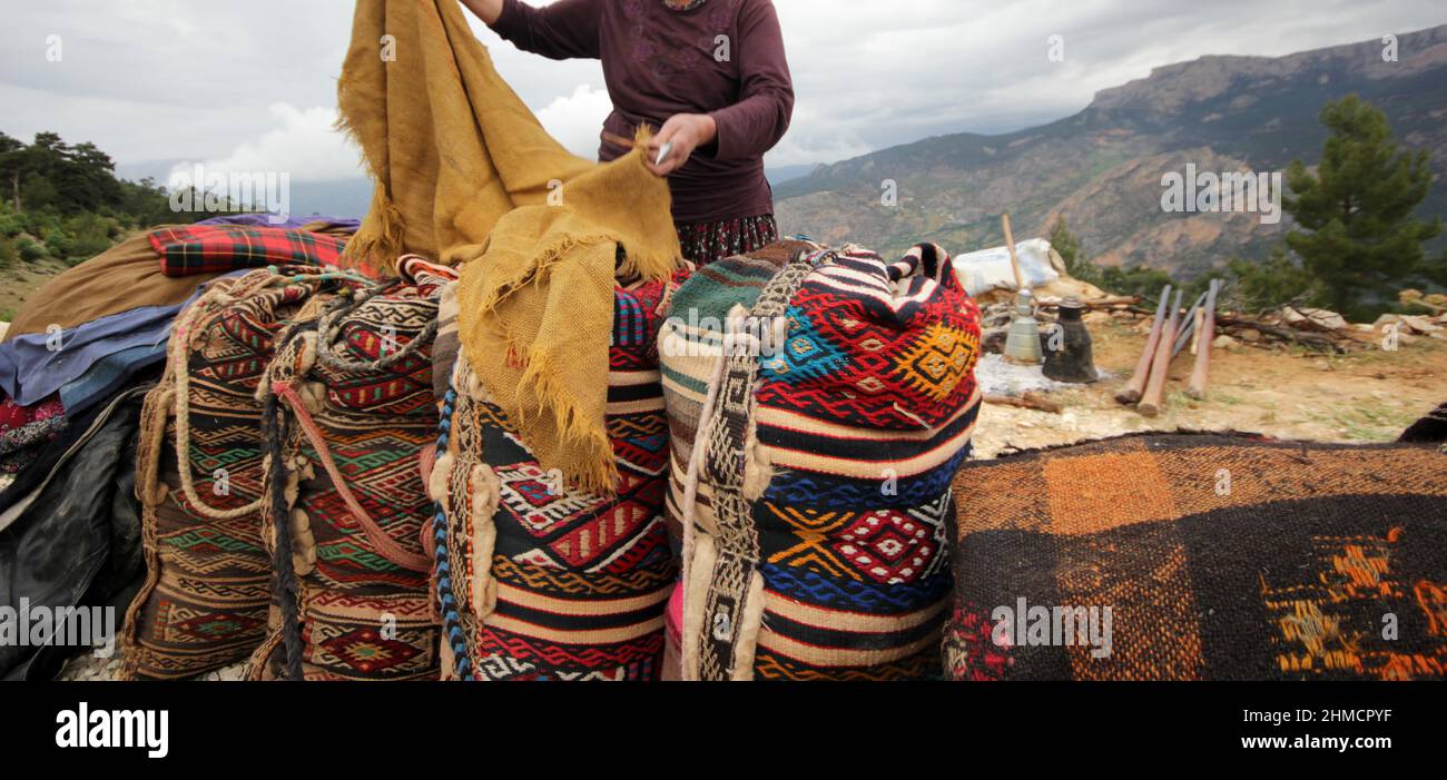 Nomadic people put their belongings in saddlebags while preparing for ...