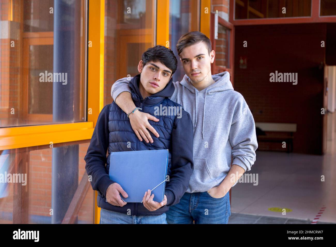 two young university student boys hugging posing while looking at the ...
