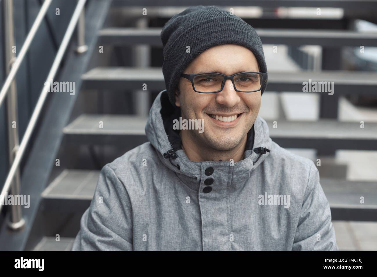 Street style portrait of handsome 30-35 years old man outdoors sitting ...