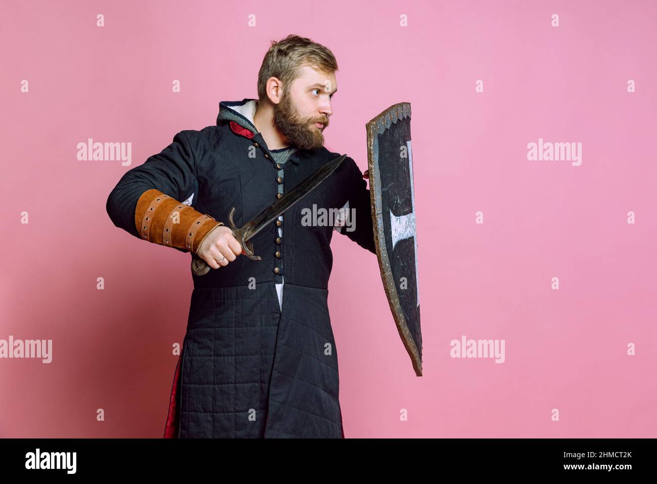Portrait of young brave man, medieval warrior or archer with sword and ...