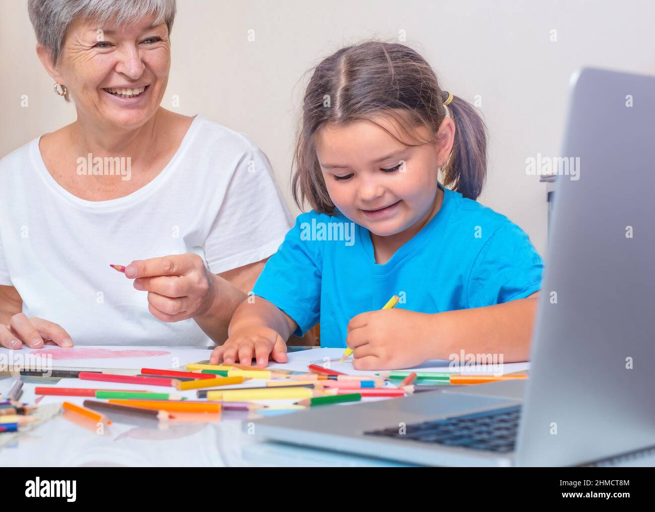 Grandmother and child learn to draw together online. Child and senior ...