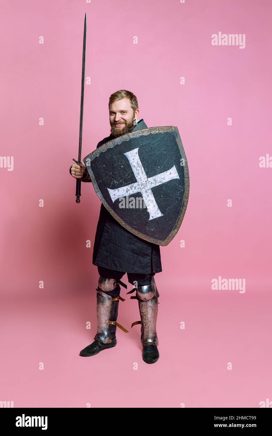 Portrait of young brave man, medieval warrior or archer with sword and ...